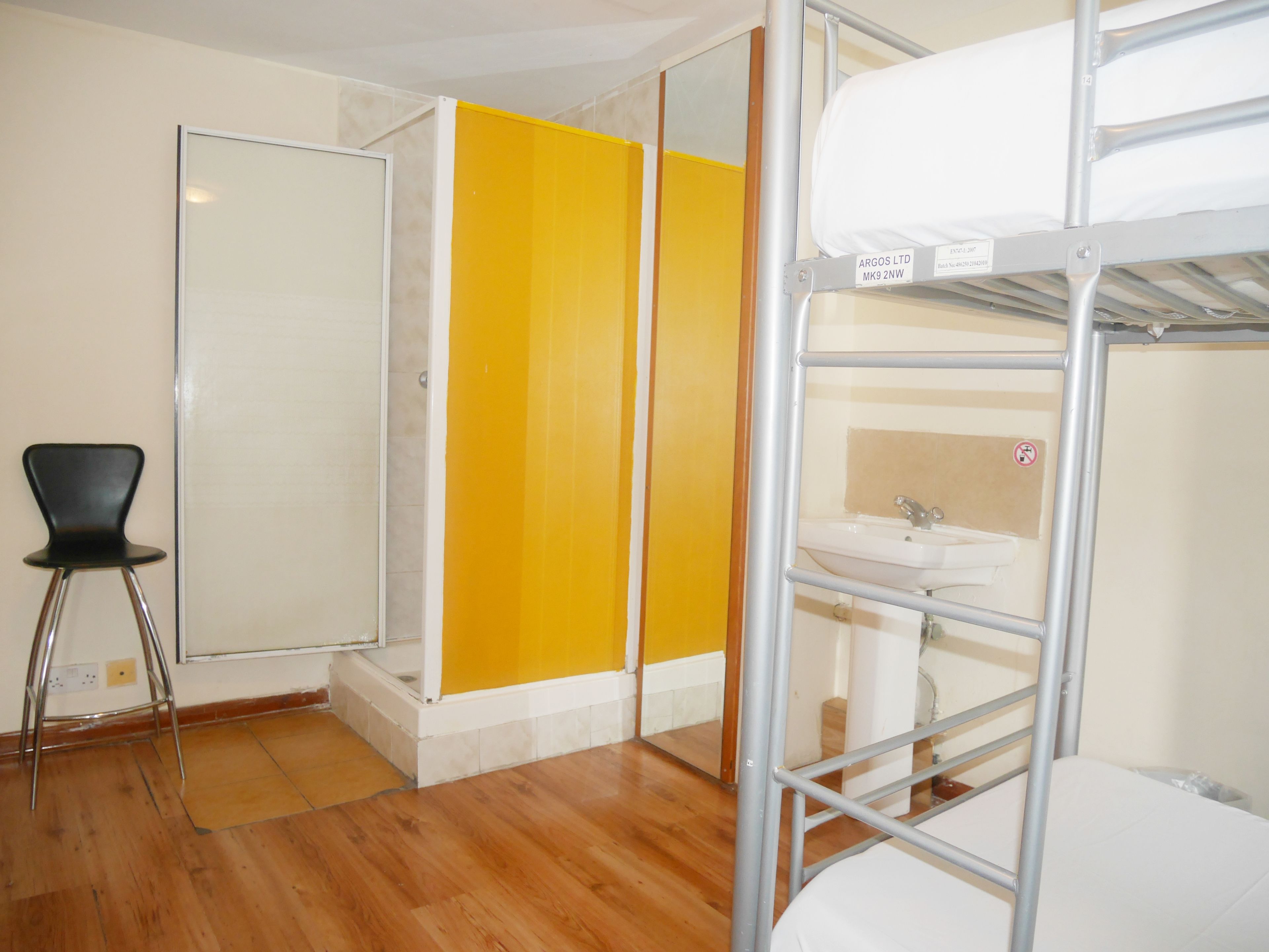 Quarto com beliche, pia e cadeira.