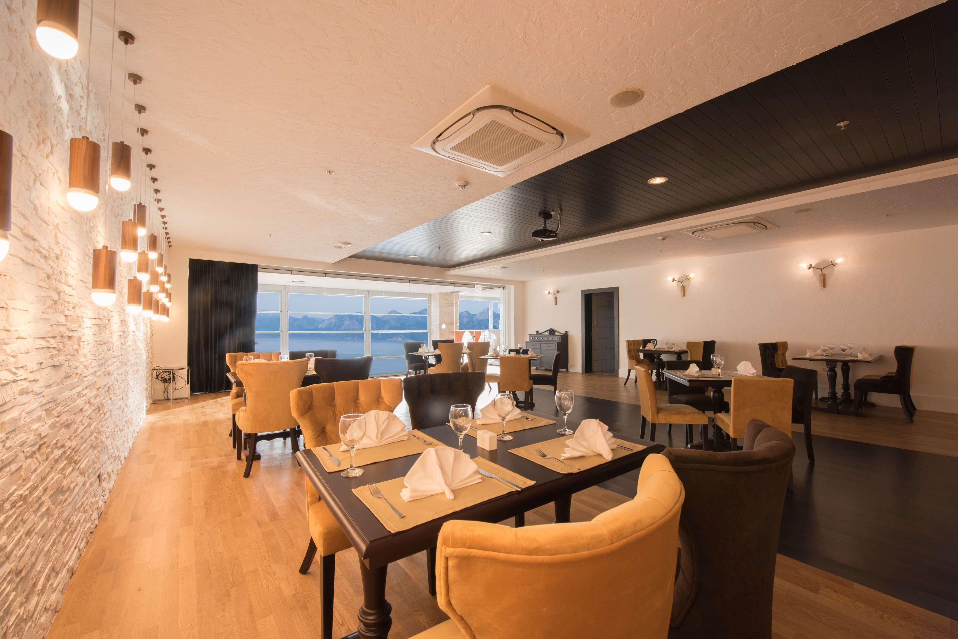 Uma sala de jantar com uma mesa comprida posta para seis pessoas, rodeada de cadeiras.
