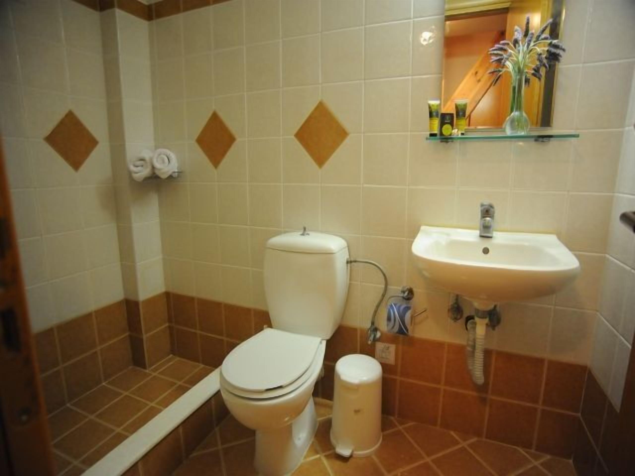 Casa de banho com sanita, lavatório e zona de duche.