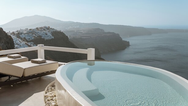 Uma área de piscina com vista para o oceano e falésias.