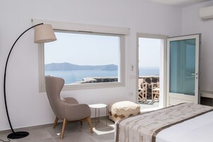 Quarto com uma janela grande, uma cadeira, uma mesa pequena e uma cama.