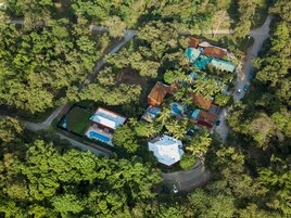 Vista aérea de um bairro residencial com casas, piscina e rua.