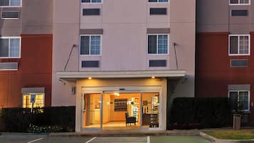 Um hotel com uma placa indicando 'CANDLEWOOD SUITES' e uma entrada visível.