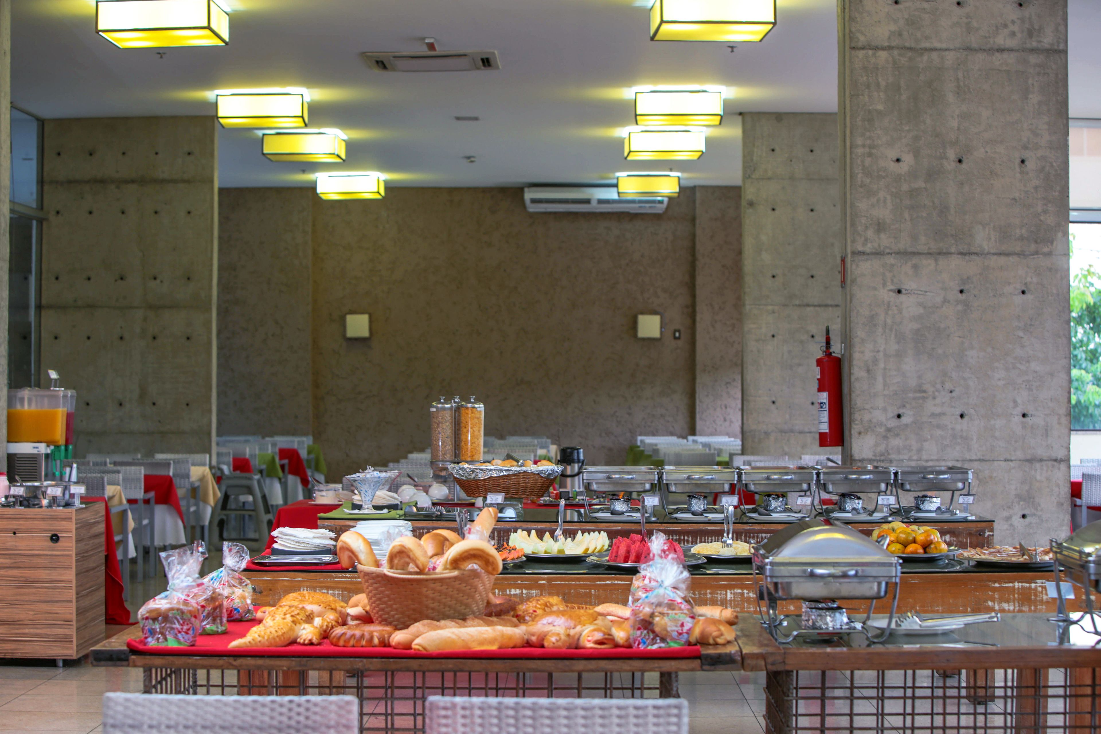 Buffet com diversos alimentos e um extintor na parede.