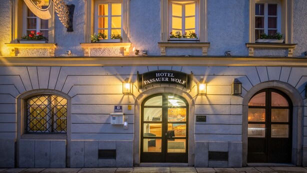 Exterior do Hotel Passauer Wolf com fachada clássica, janelas amplas e uma placa chamativa.