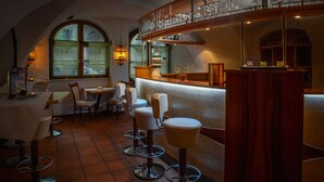 Restaurante com área de bar, vários bancos e piso de azulejos.