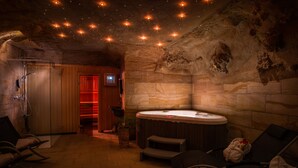 Sala de spa com hidromassagem, área de estar e chuveiro.