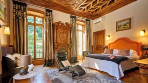 Quarto com cama, cadeira, mesa e lareira.