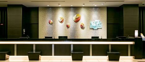 Uma receção com o logótipo Holiday Inn, uma parede de mosaico em azulejos e um design moderno.