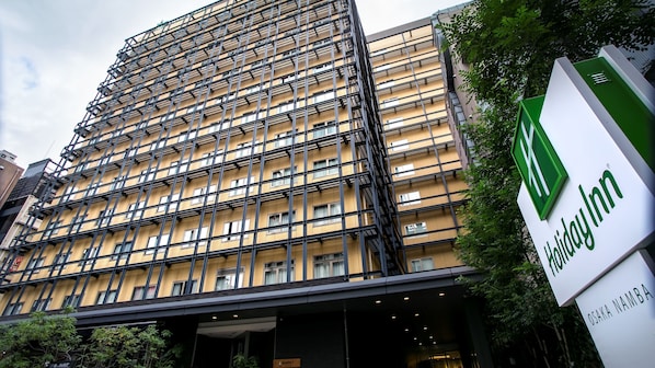 Um edifício de vários andares com design arquitetônico moderno, com uma placa Holiday Inn bem visível.