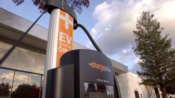 Uma estação de carregamento para veículos elétricos, com sinalização indicando uso exclusivo para carregamento de veículos elétricos.