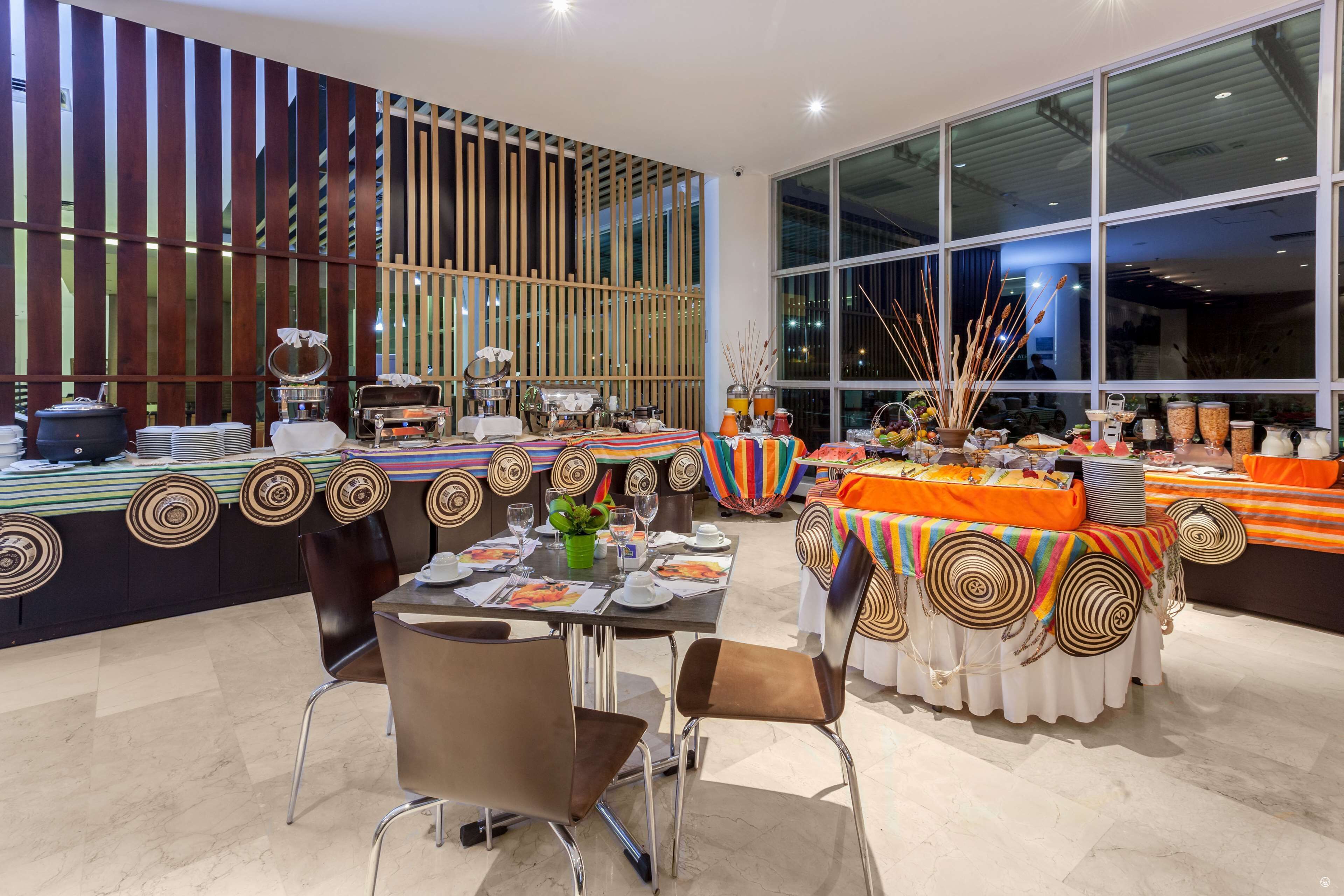 Uma sala de jantar moderna com mesas redondas, cadeiras e uma parede decorativa.