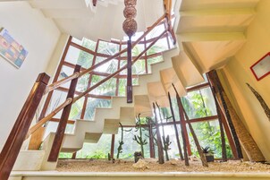Escada em espiral com vista para plantas tropicais lá fora.