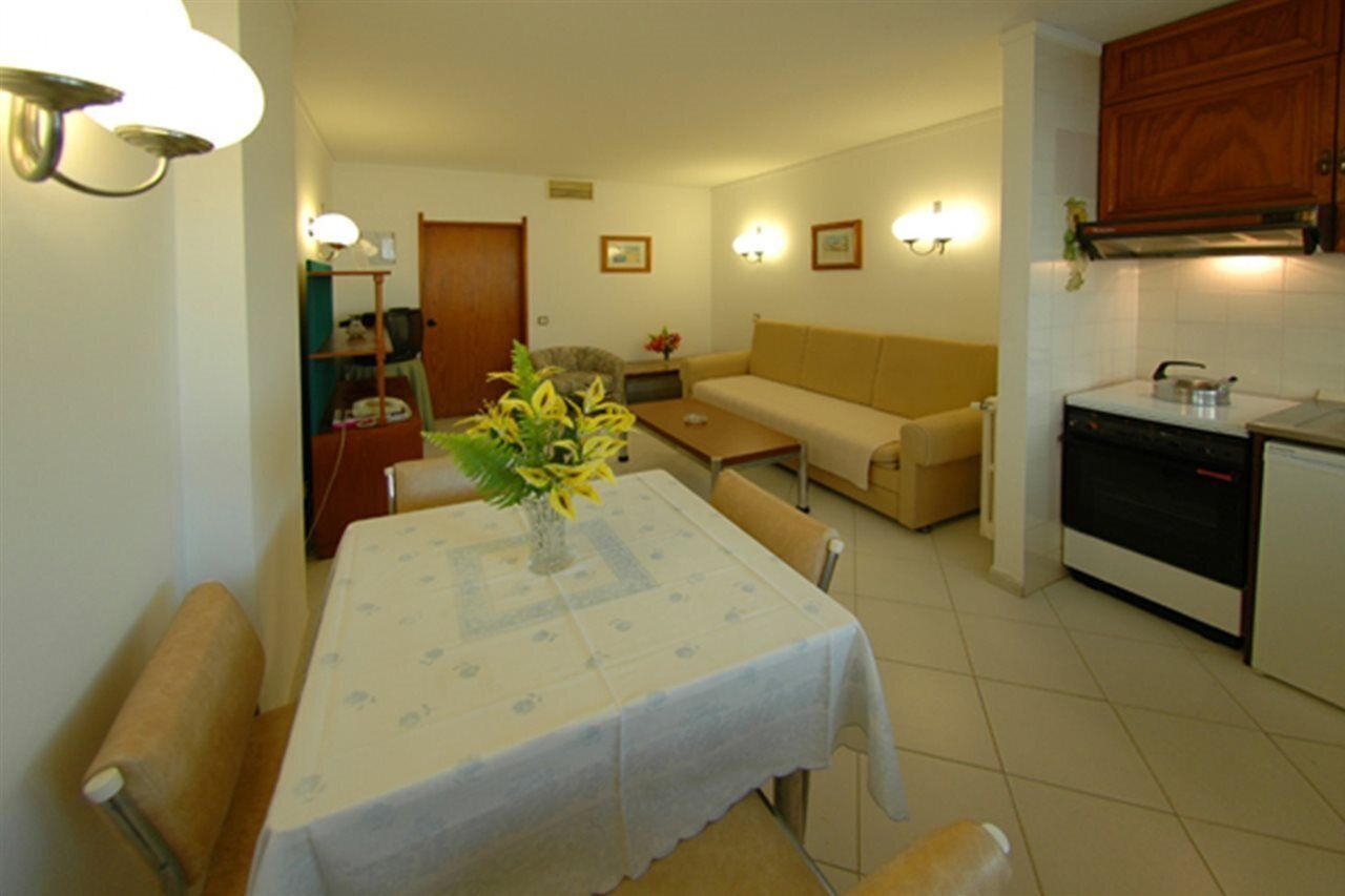 Um espaço compacto com mesa de jantar, sofá e cozinha compacta.