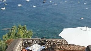 Um pátio com mesa e cadeiras, com vista para uma marina e barcos.