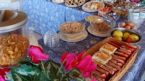 Uma mesa de buffet com diversos alimentos, incluindo pão, doces e frutas.