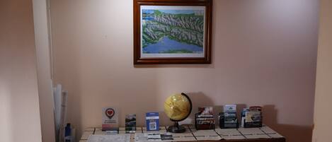 Uma mesa com um mapa emoldurado, um globo e vários livros e caixas.