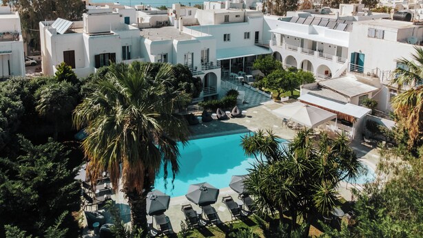 Um resort com piscina, espreguiçadeiras e vista para o mar.