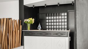 Cozinha moderna com armário branco, painel de parede preto e parede de ripas de madeira.
