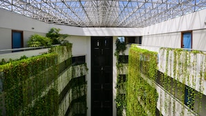 Um edifício moderno com teto de vidro e jardins verticais.