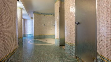Um corredor com paredes e chão azulejados, apresentando um design curvo e uma câmera de segurança.
