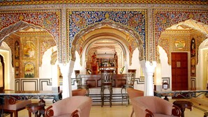 Interior ornamentado com área de bar, assentos e decoração detalhada nas paredes e no teto.