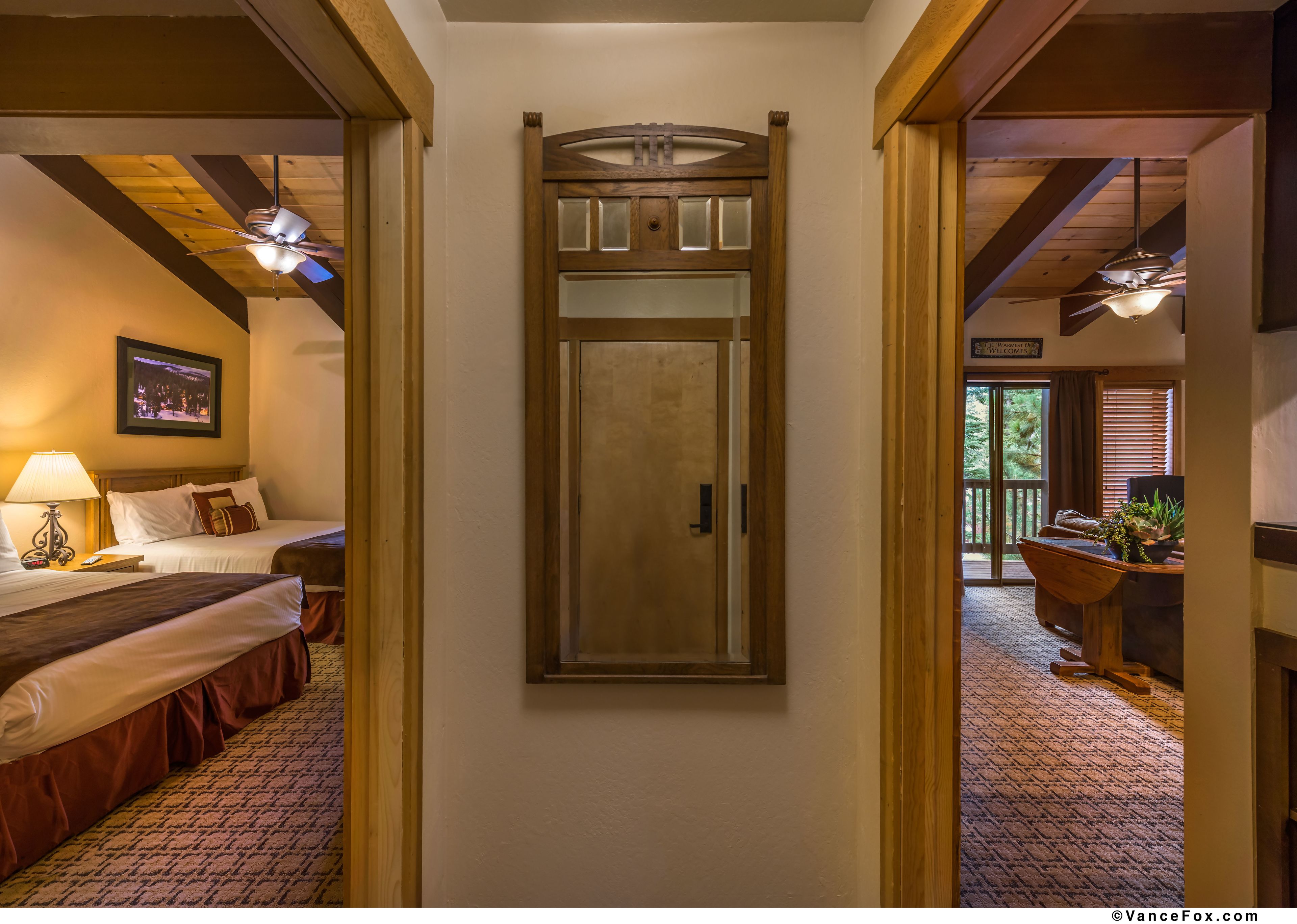 Quarto de hotel com cama, mesa de cabeceira, abajur e vista para o exterior.