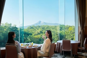 Duas pessoas sentadas à mesa com vista para a montanha.