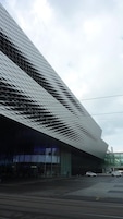 Um edifício moderno com fachada geométrica marcante e amplas janelas.
