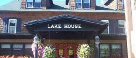 Um edifício com uma placa na entrada que diz 'LAKE HOUSE'.