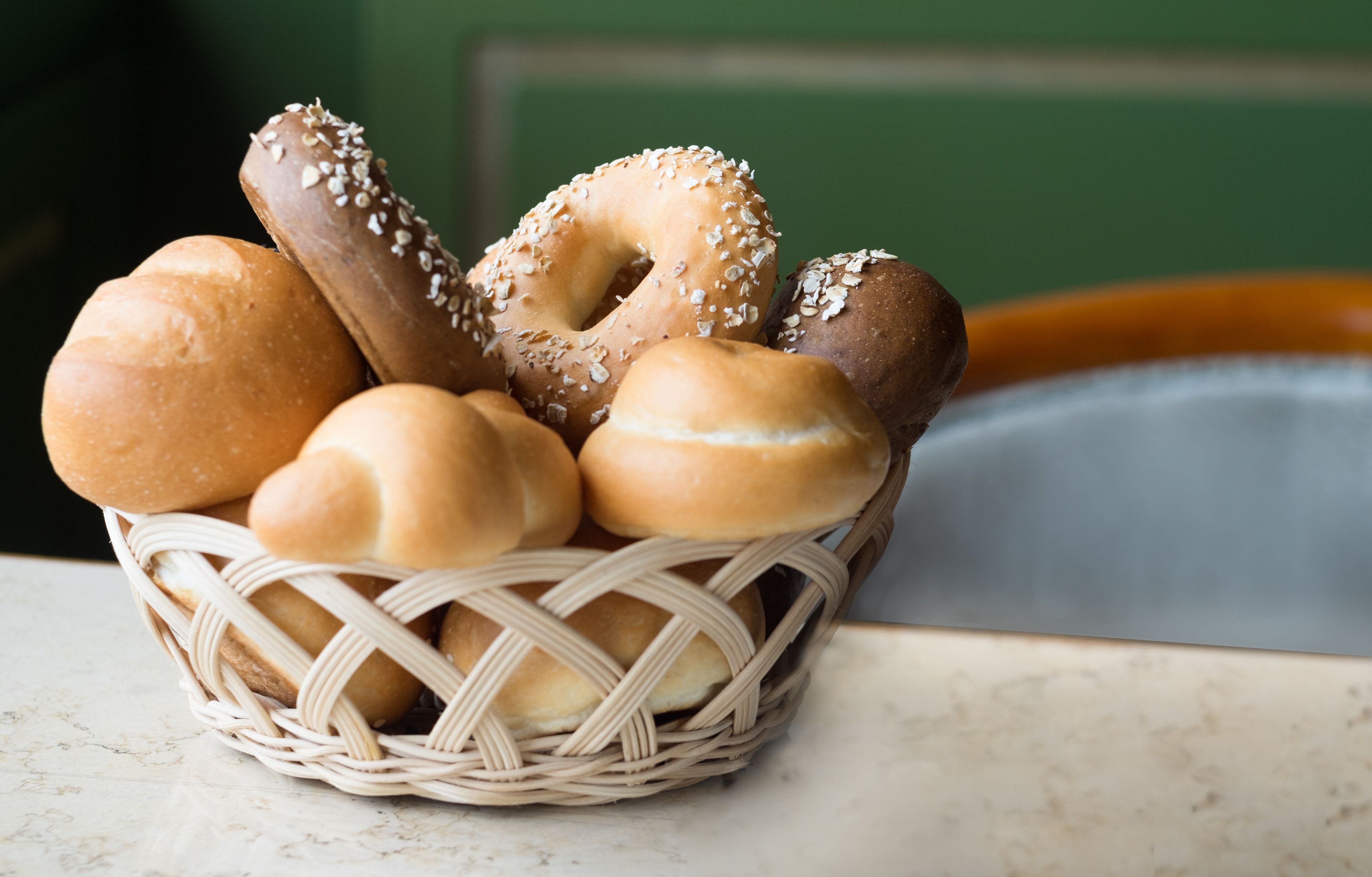 Uma cesta com vários pães e pãozinhos.