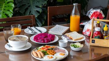 Uma mesa de café da manhã com diversos pratos, bebidas, acompanhamentos e um livro.