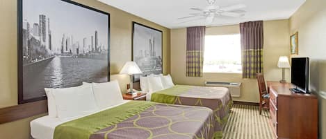 Quarto de hotel com duas camas, uma escrivaninha, televisão, ventoinha no teto e grandes quadros com vista para a cidade.