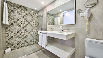 Um banheiro moderno com azulejos estampados, um lavatório branco, chuveiro e vaso sanitário.