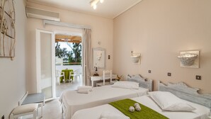Quarto de hotel com duas camas, uma escrivaninha e uma cadeira. Tem uma varanda com mesa e cadeiras.