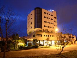 Um hotel com vários andares e um letreiro grande com a palavra 'HOTEL' no topo.