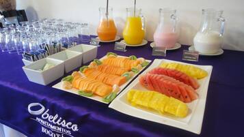 Uma mesa de buffet com diversas frutas e bebidas.