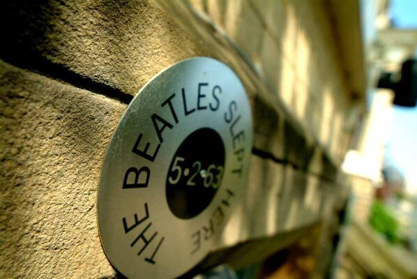 Uma placa de metal com a inscrição 'THE BEATLES' e a data '5-2-63'.