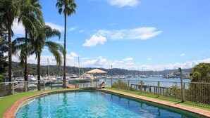 Piscina com vista para um porto e barcos.