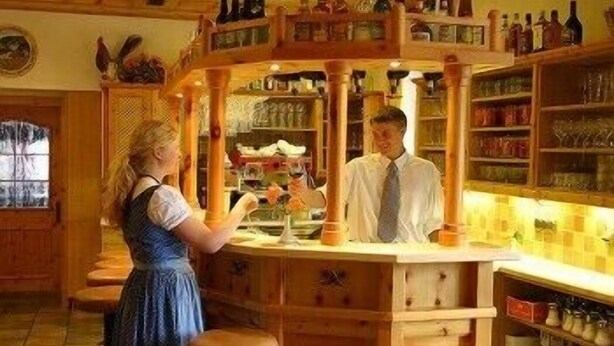 Uma área de bar com decoração em madeira e prateleiras de garrafas.