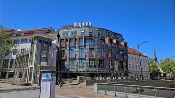 Um hotel chamado 'Bayjonn' com design arquitetônico moderno, com vários andares e grandes janelas.
