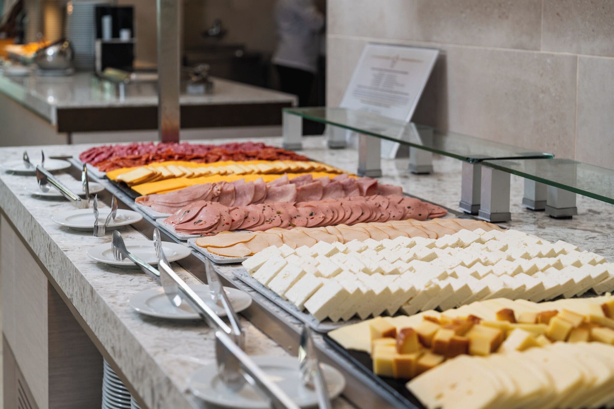 Buffet variado com carnes, queijos e outros pratos preparados.