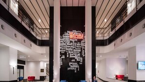 Um hall amplo com um grande letreiro de 'Welcome', assentos confortáveis e design moderno.