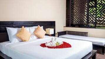 Quarto de hotel com duas camas, uma cabeceira, uma mesa de cabeceira e um painel decorativo na parede.