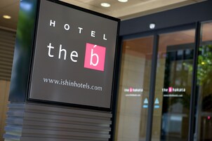 Placa de hotel com o nome 'HOTEL the b' e o site 'www.ishinhotels.com'.