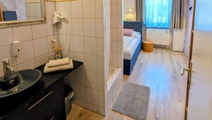 Uma casa de banho moderna com lavatório, espelho e porta-toalhas.