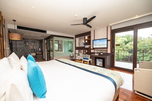 Quarto moderno com uma cama grande, uma escrivaninha e uma televisão.