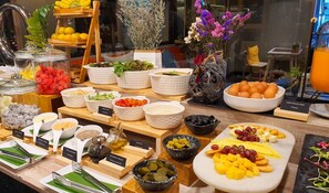 Buffet com diversos alimentos e acompanhamentos.