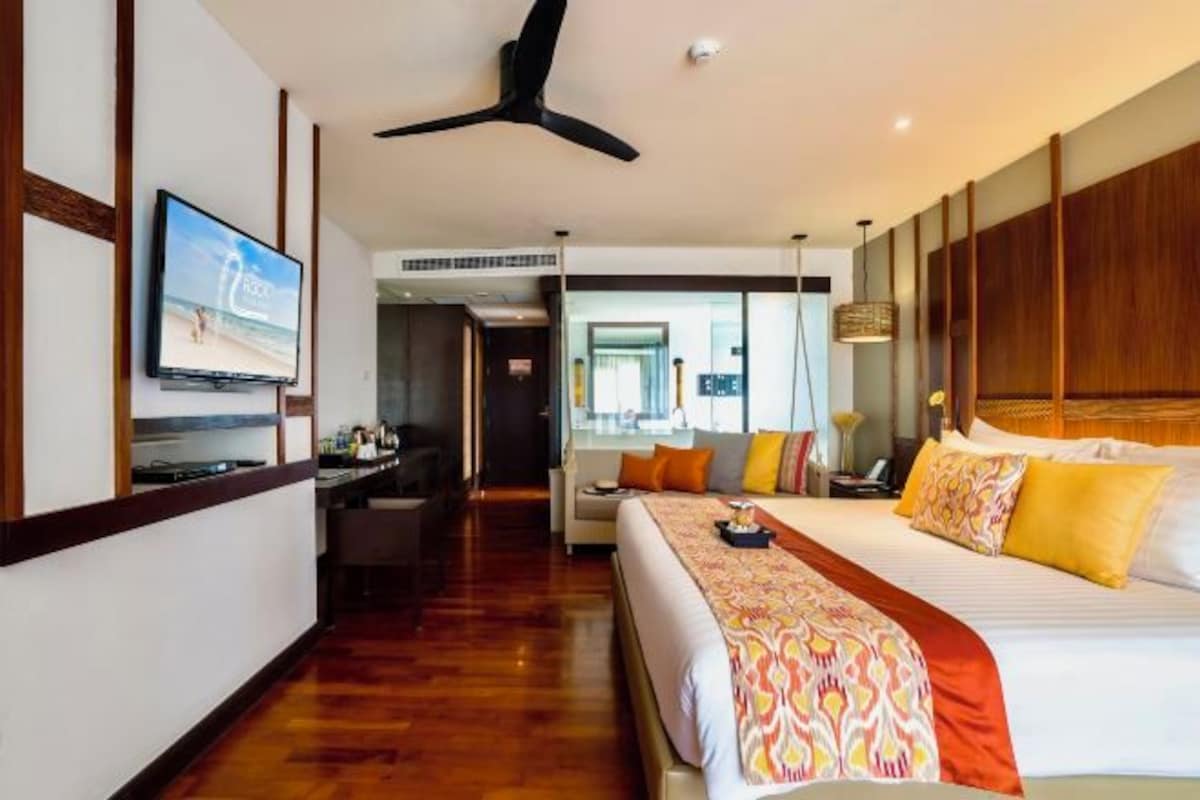 Quarto de hotel com uma cama, televisão, escrivaninha e vista para o exterior.