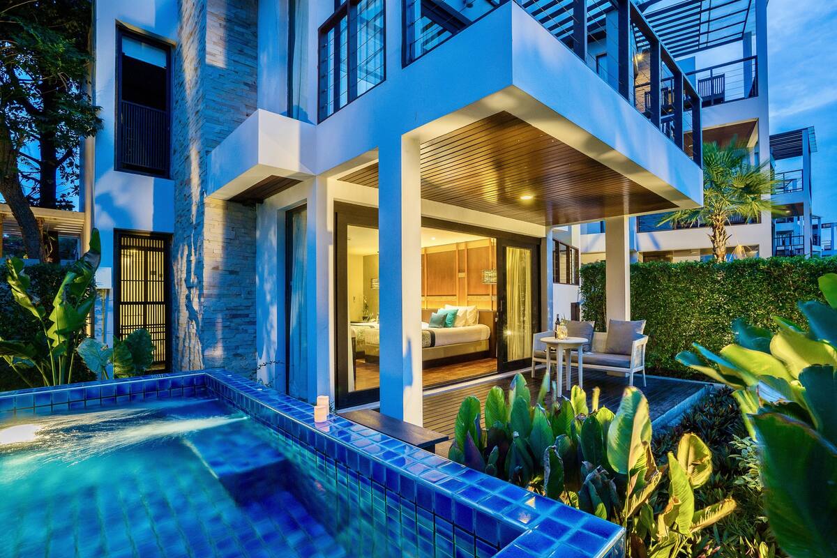 Um hotel moderno com piscina, área de estar ao ar livre e um jardim bem cuidado.